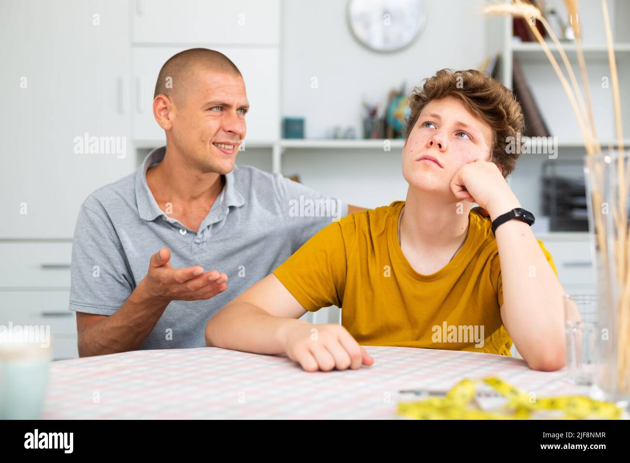 Son feeling sad and father talking to him Stock Photo - Alamy