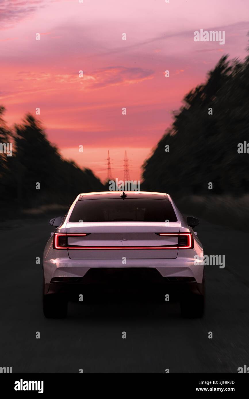 A vertical back view of a white Electric Polestar 2 driving towards ...