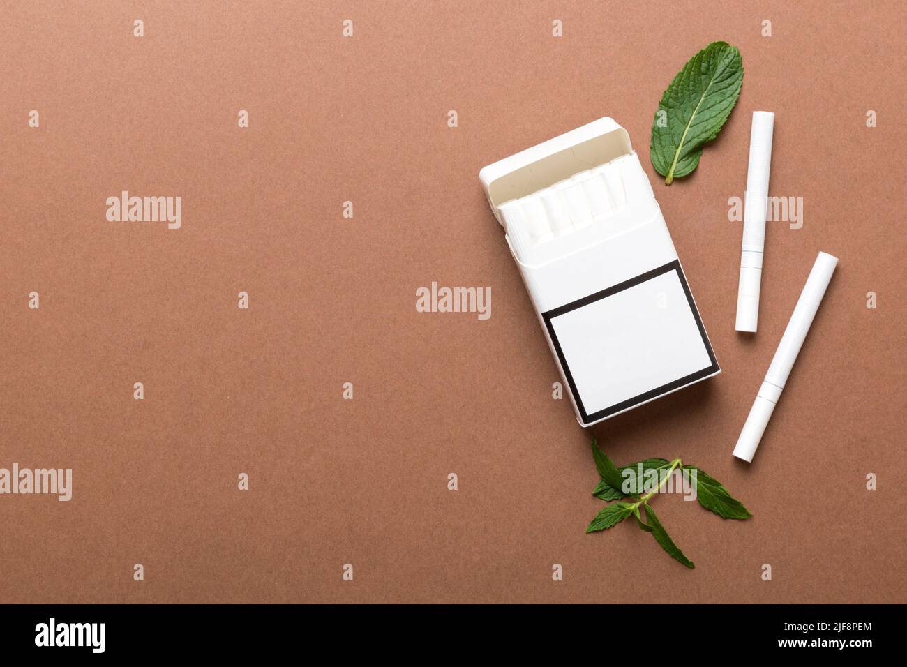 Pack of menthol cigarettes and fresh mint on colored table, Menthol ...