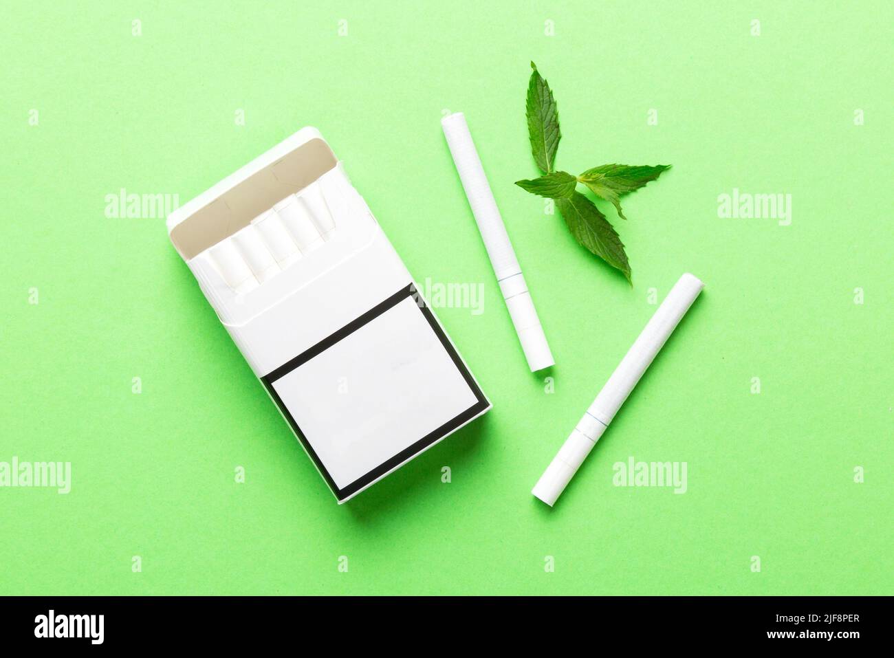 Pack of menthol cigarettes and fresh mint on colored table, Menthol ...