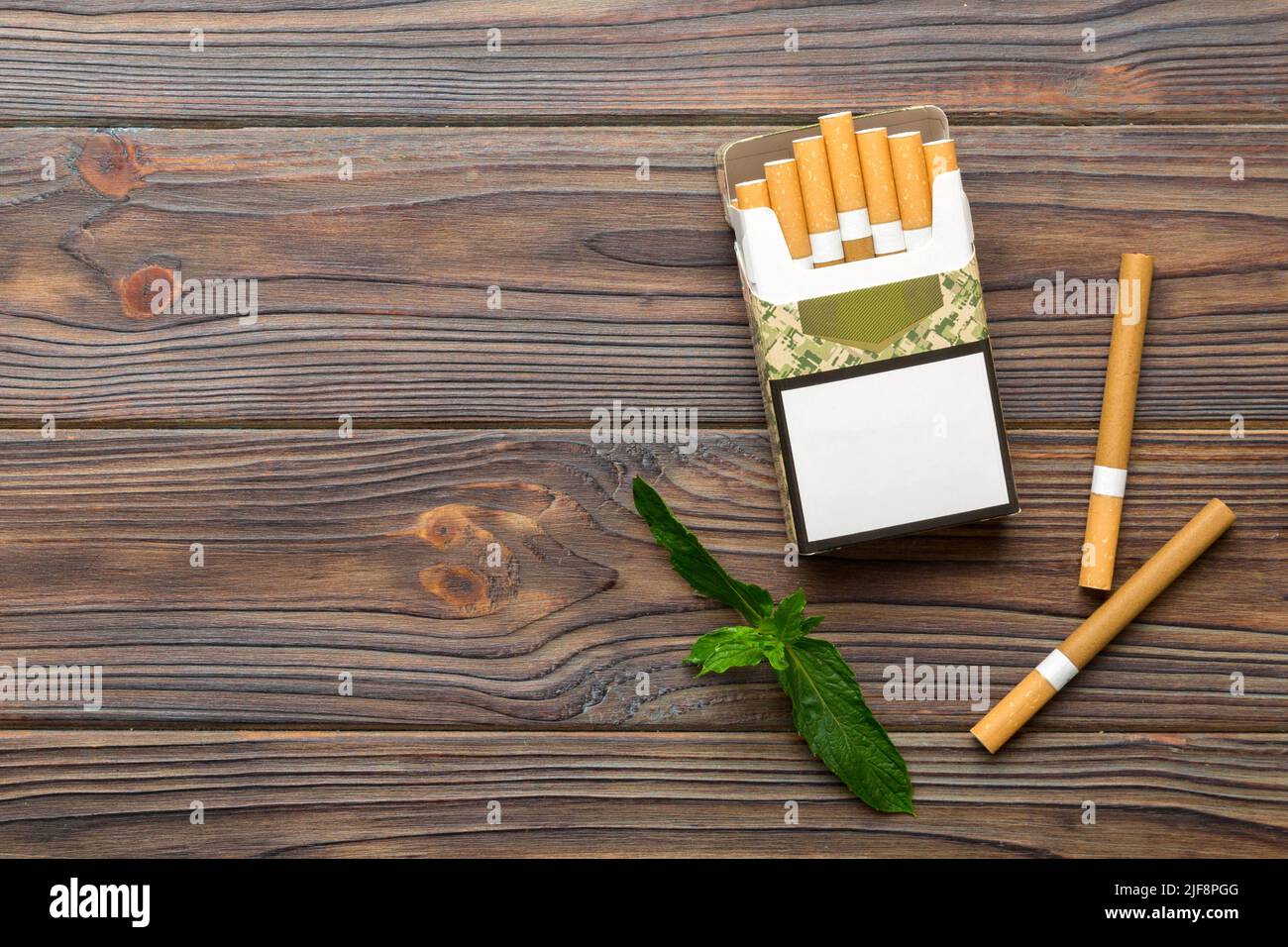 Pack of menthol cigarettes and fresh mint on colored table, Menthol ...