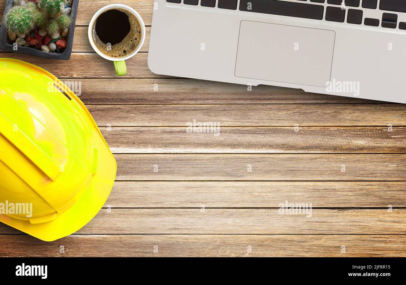 Top view with laptop computer,safety helmet and cup of coffee on wood ...