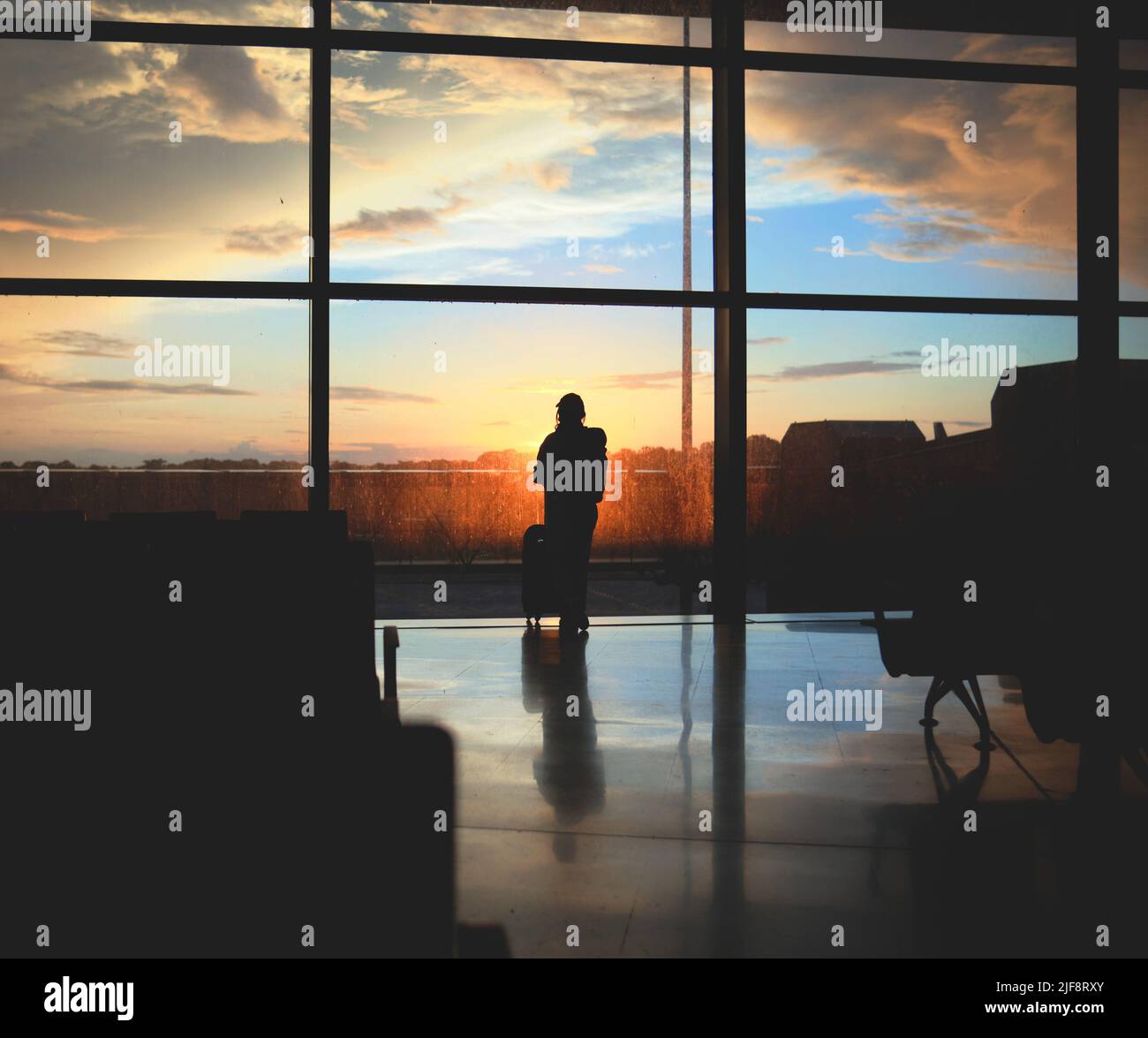 Start of her journey. Beautiful young woman looking out window at ...