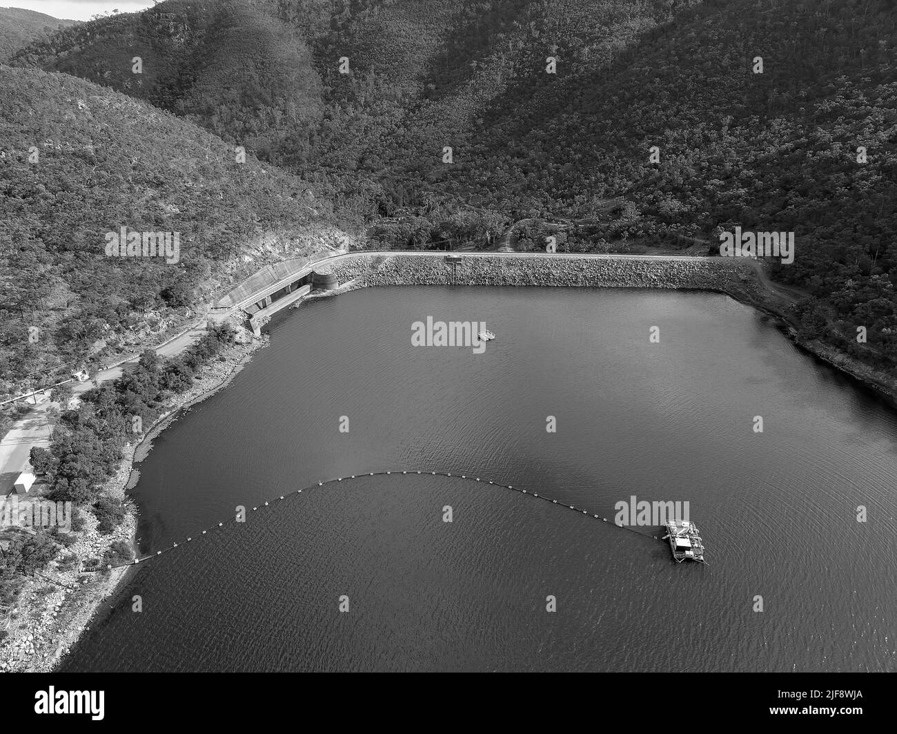 Eungella Dam wall built between mountains with overflow channel and ...