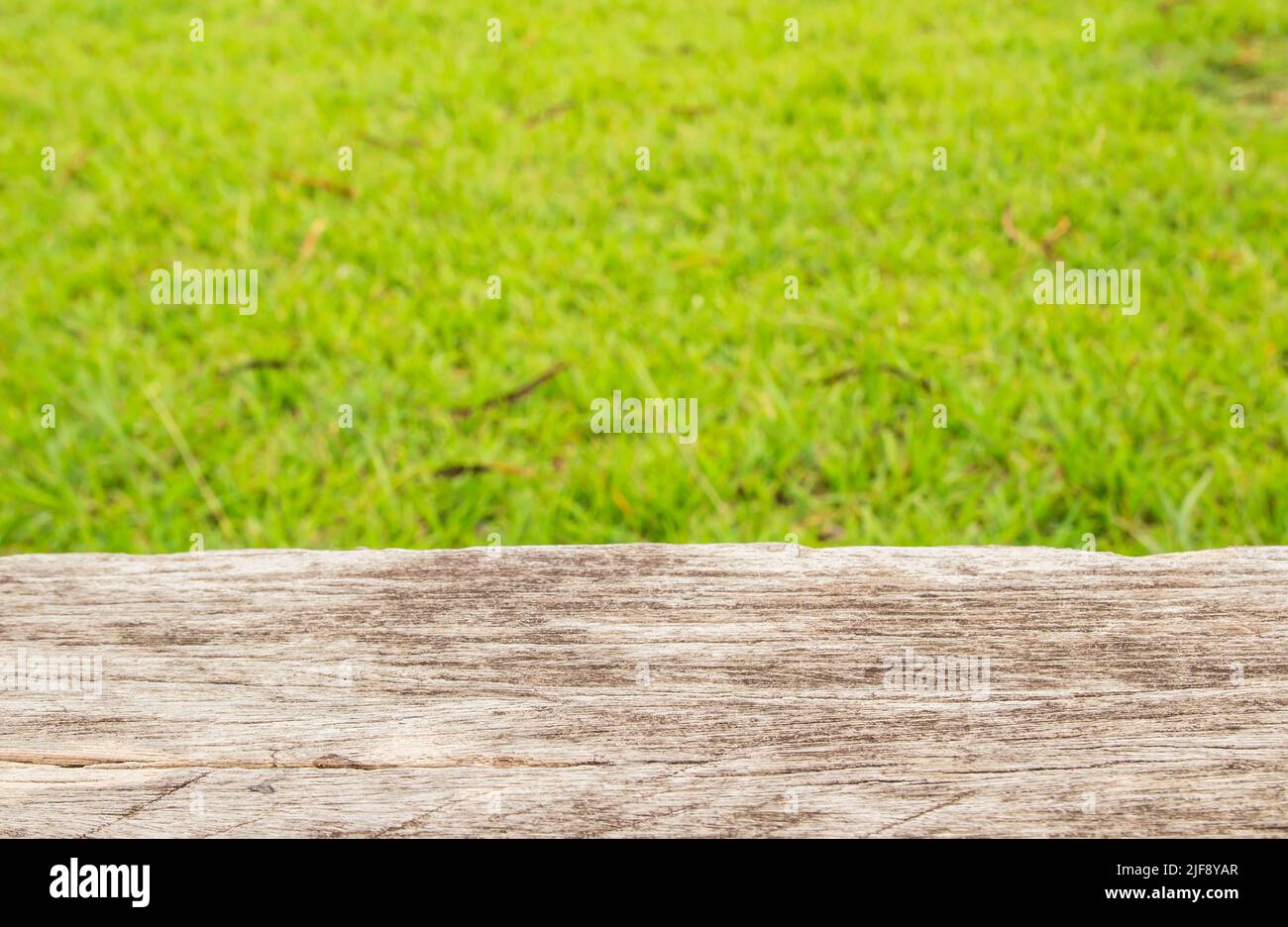 Wooden table with blurred green grass background Stock Photo - Alamy