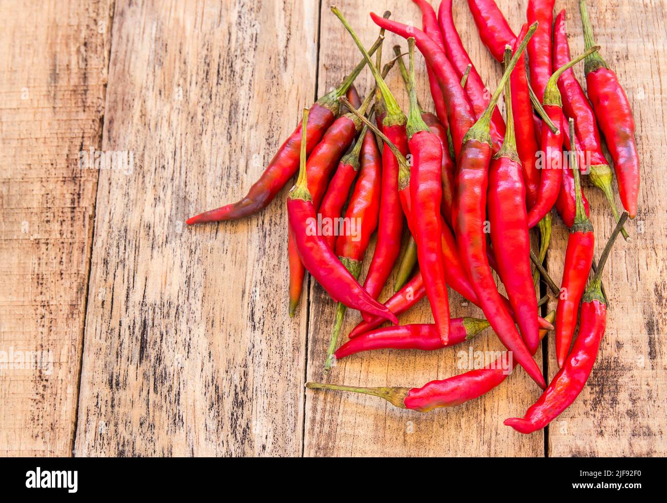 Red hot chili peppers on old wooden table background Stock Photo - Alamy