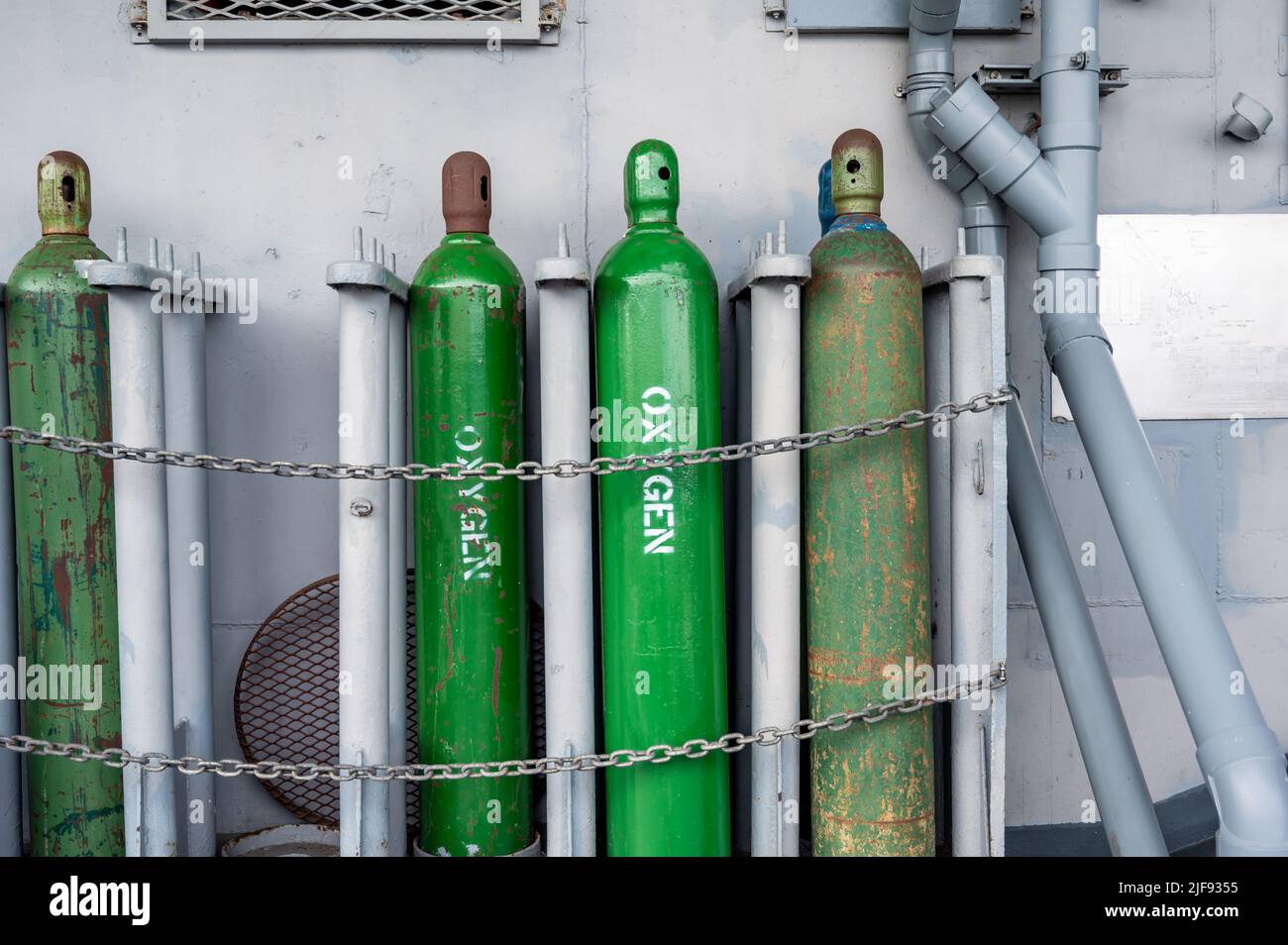 Compressed gas cylinders being stored vertically secured by a metal ...