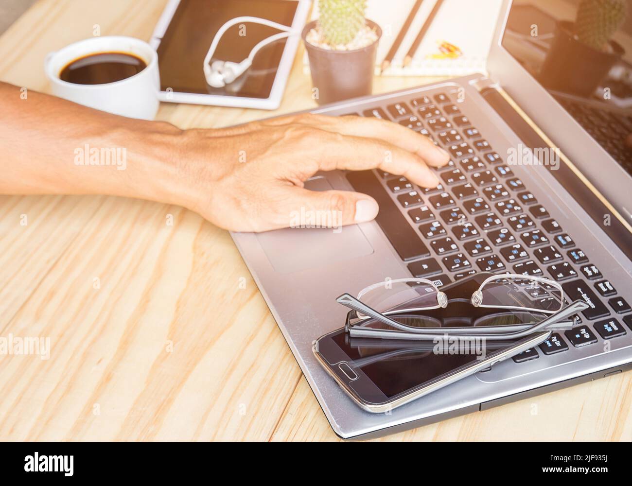 Business man is working by using a laptop computer on wooden desk ...