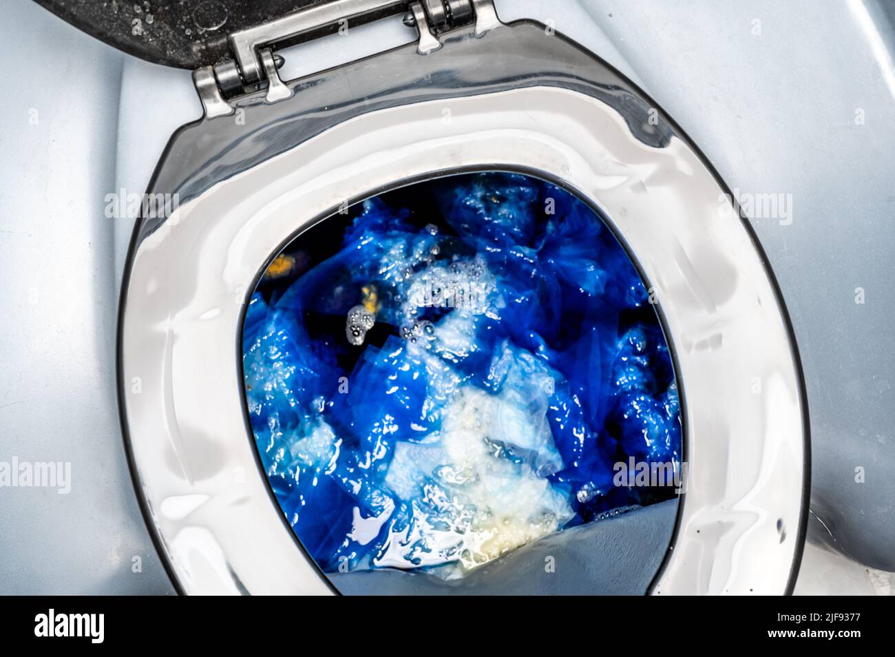 Inside a portable toilet with blue deodorizing disinfectant liquid ...