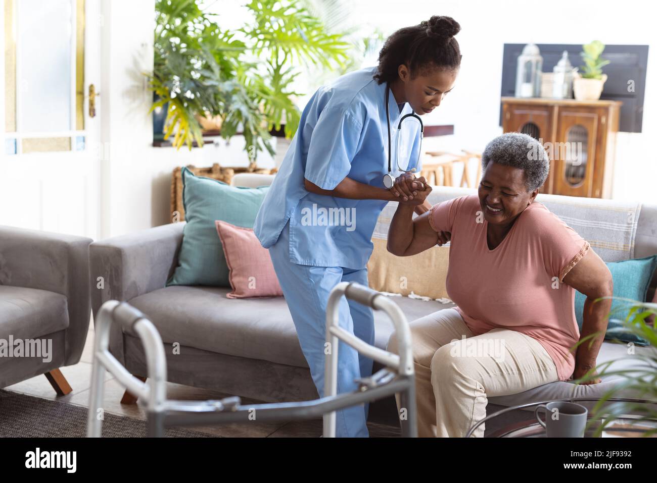 African american young doctor assisting senior female patient in ...