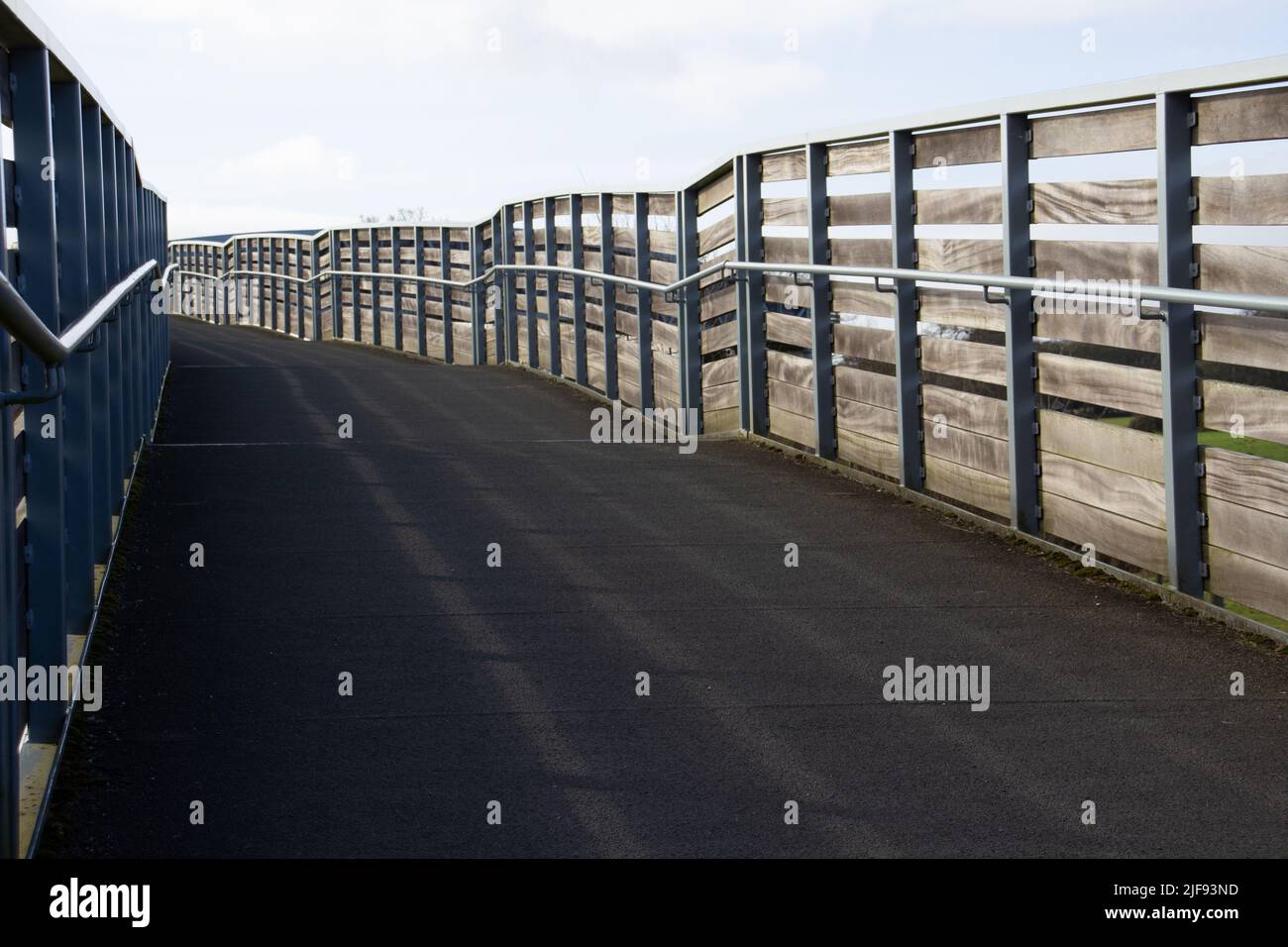 shared-use path up to a bridge in morning shadow and a blue sky with ...