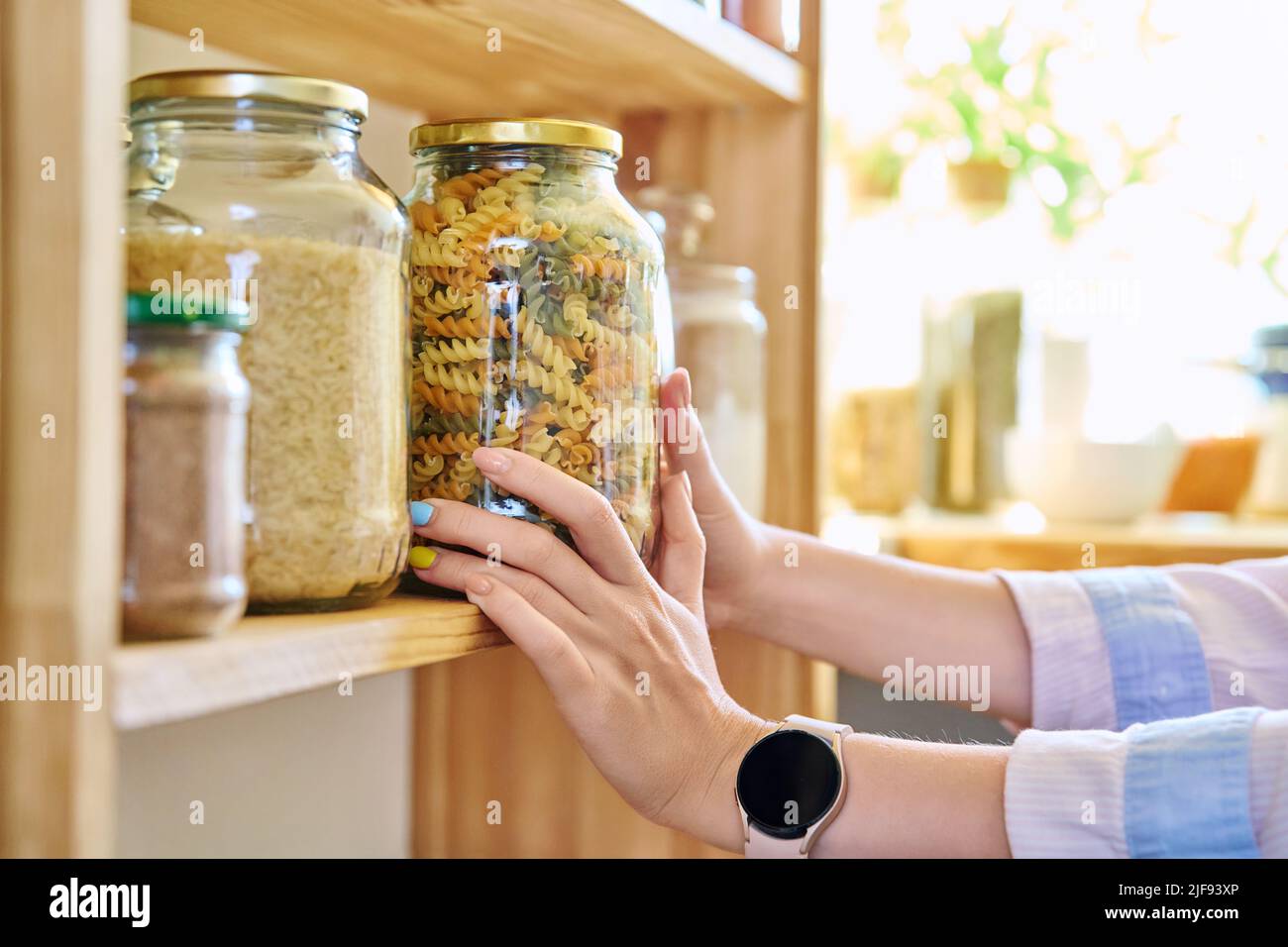 Storage of food in the kitchen in pantry, woman's hands with jar of ...