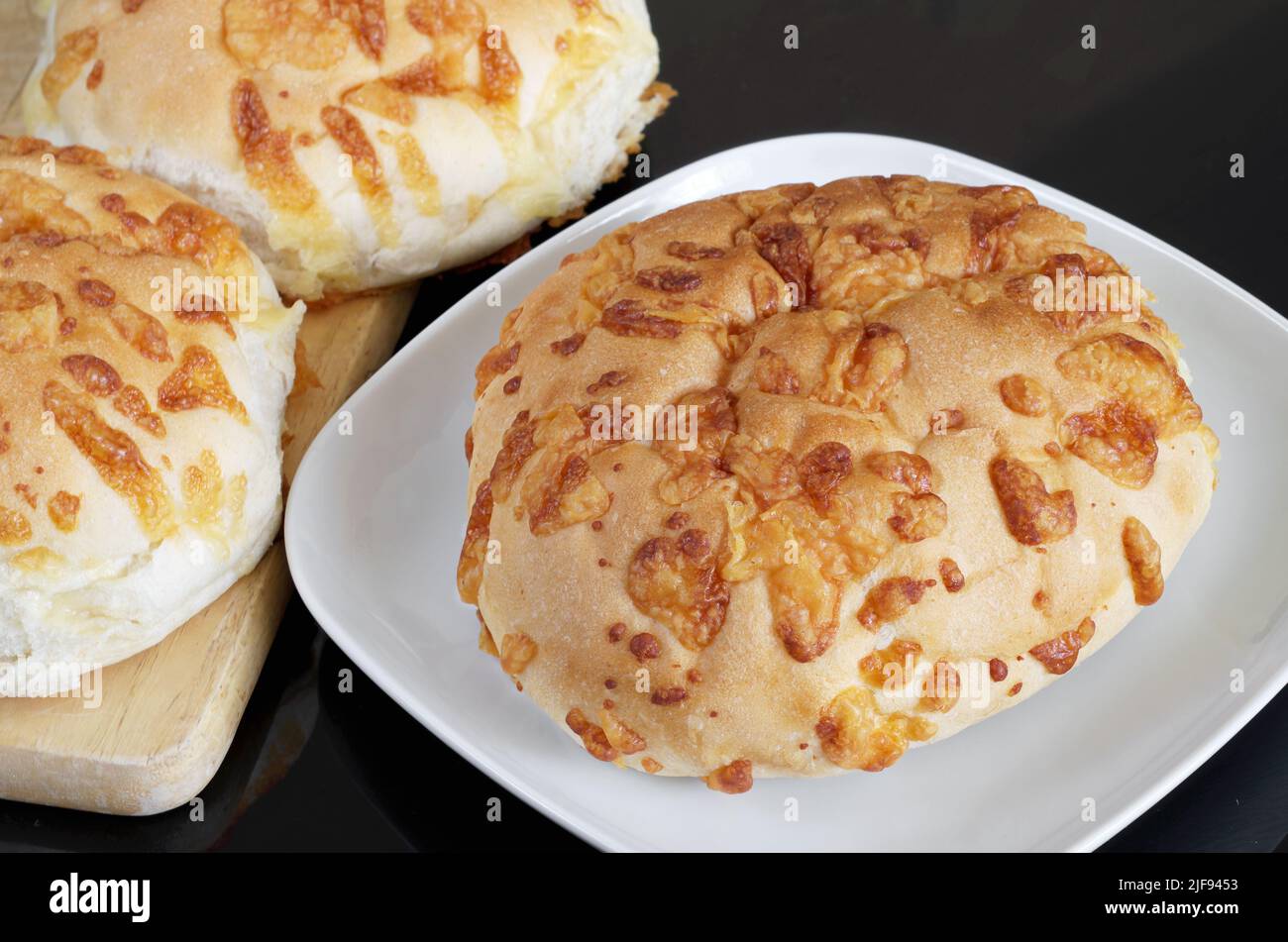Round cheese buns - big bite rolls on black table close up Stock Photo - Alamy