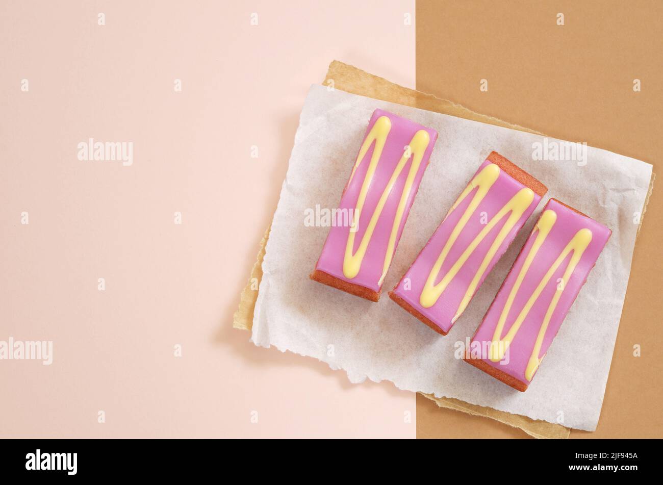 Slices of layers cake topped with fondant icing on two-tone background ...