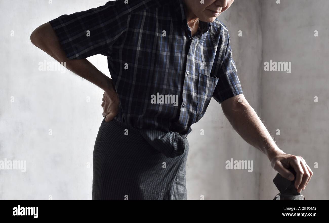 Asian elder man suffering from right sided low back and loin pain. It ...