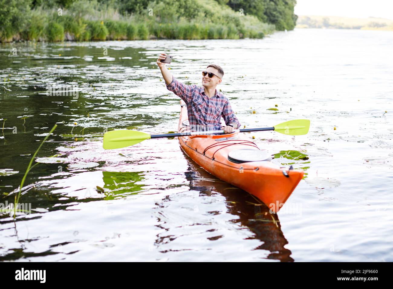 Kayaking on the river. Young Caucasian man sitting in a kayak and ...