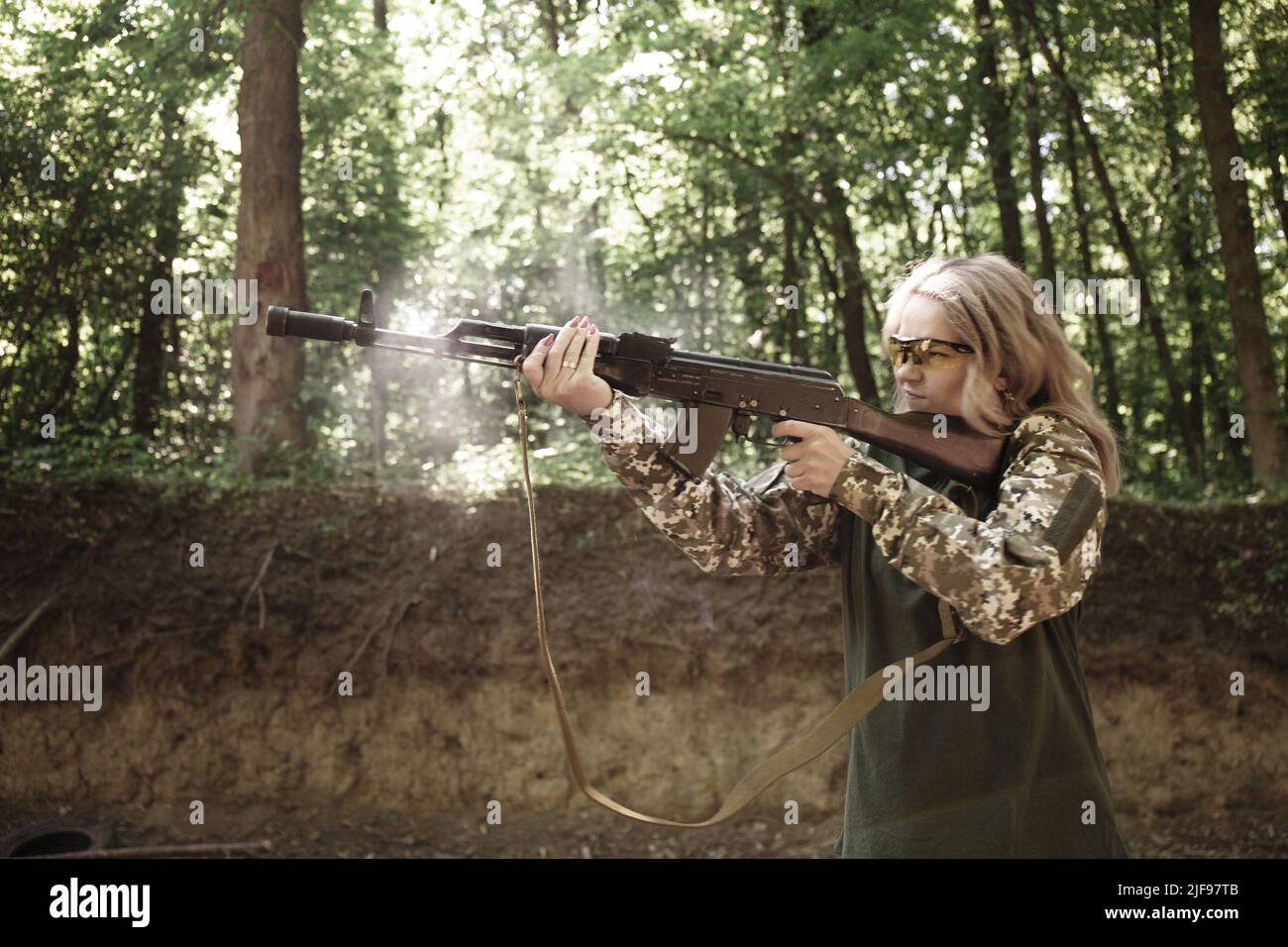 A Ukrainian woman is training to shoot an Akm machine gun during ...