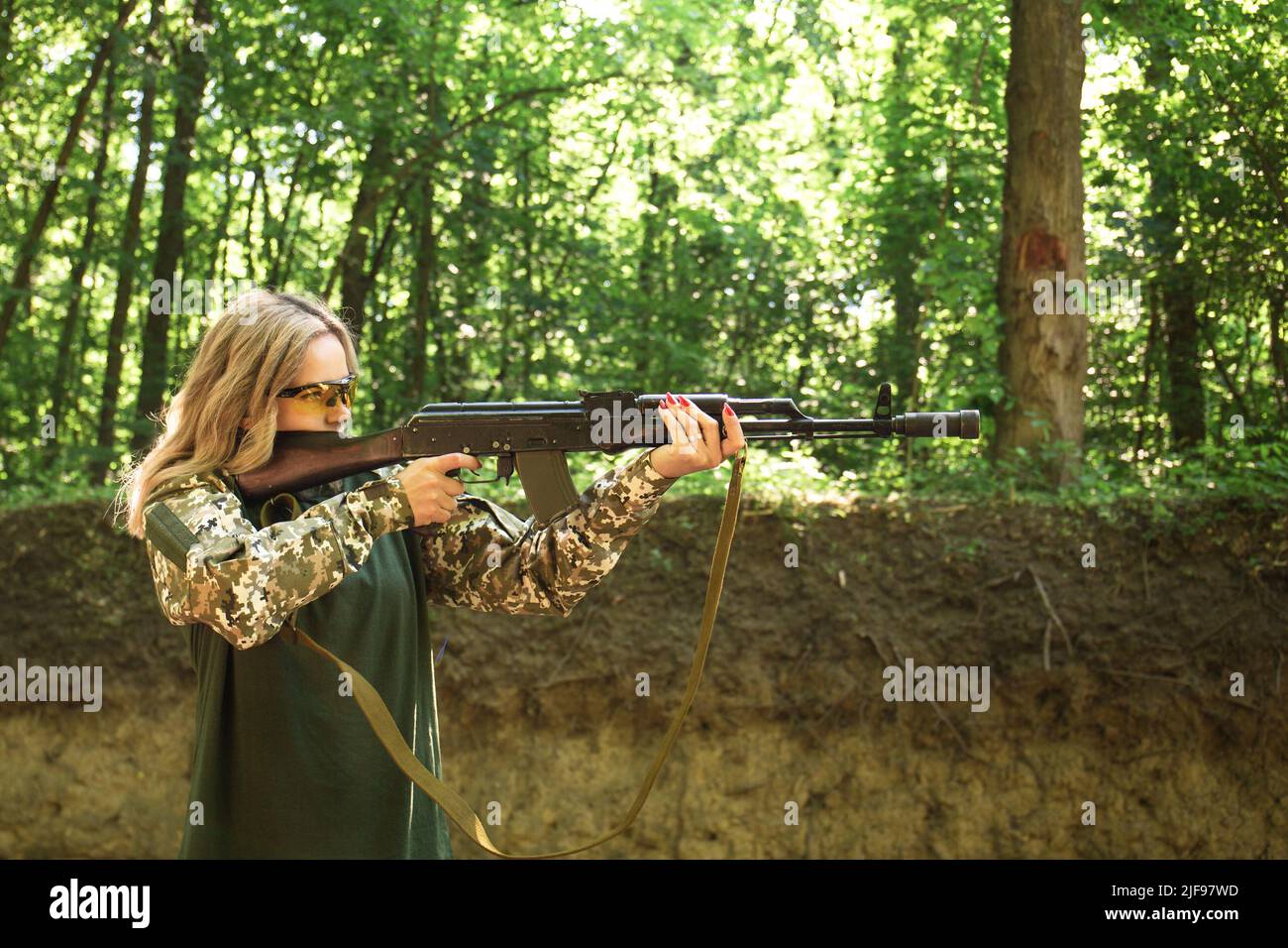 A Ukrainian woman is training to shoot an Akm machine gun during ...