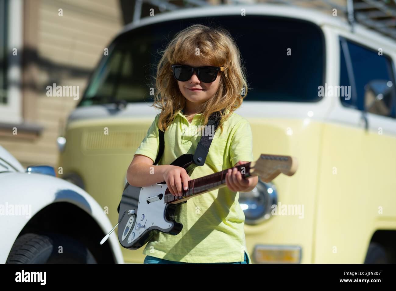 Child musician playing the guitar like a rockstar outdoor. Kid boy rock ...