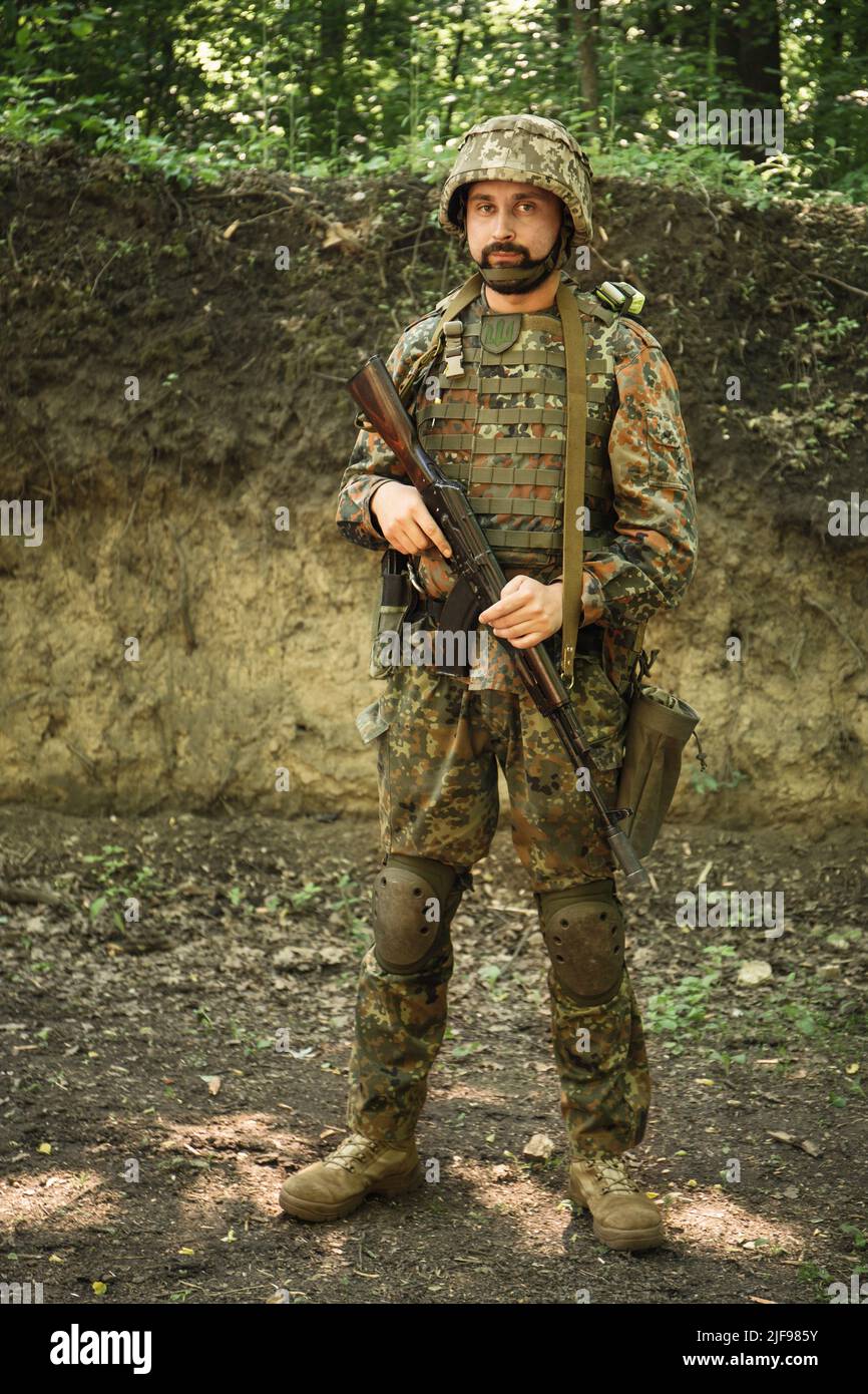 Portrait of a Ukrainian military man with a Kalashnikov assault rifle ...