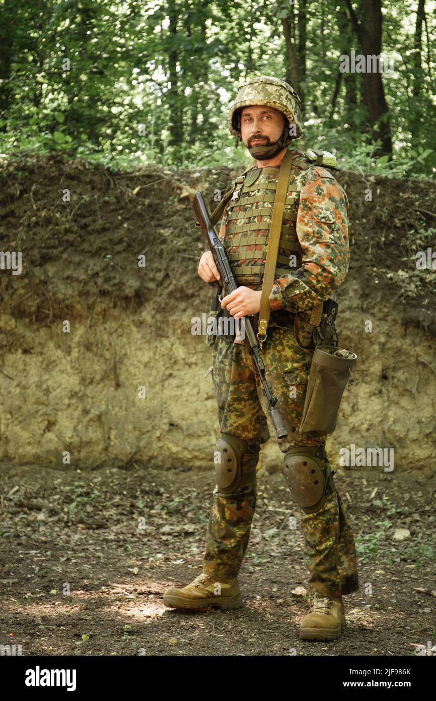 Portrait of a Ukrainian military man with a Kalashnikov assault rifle ...