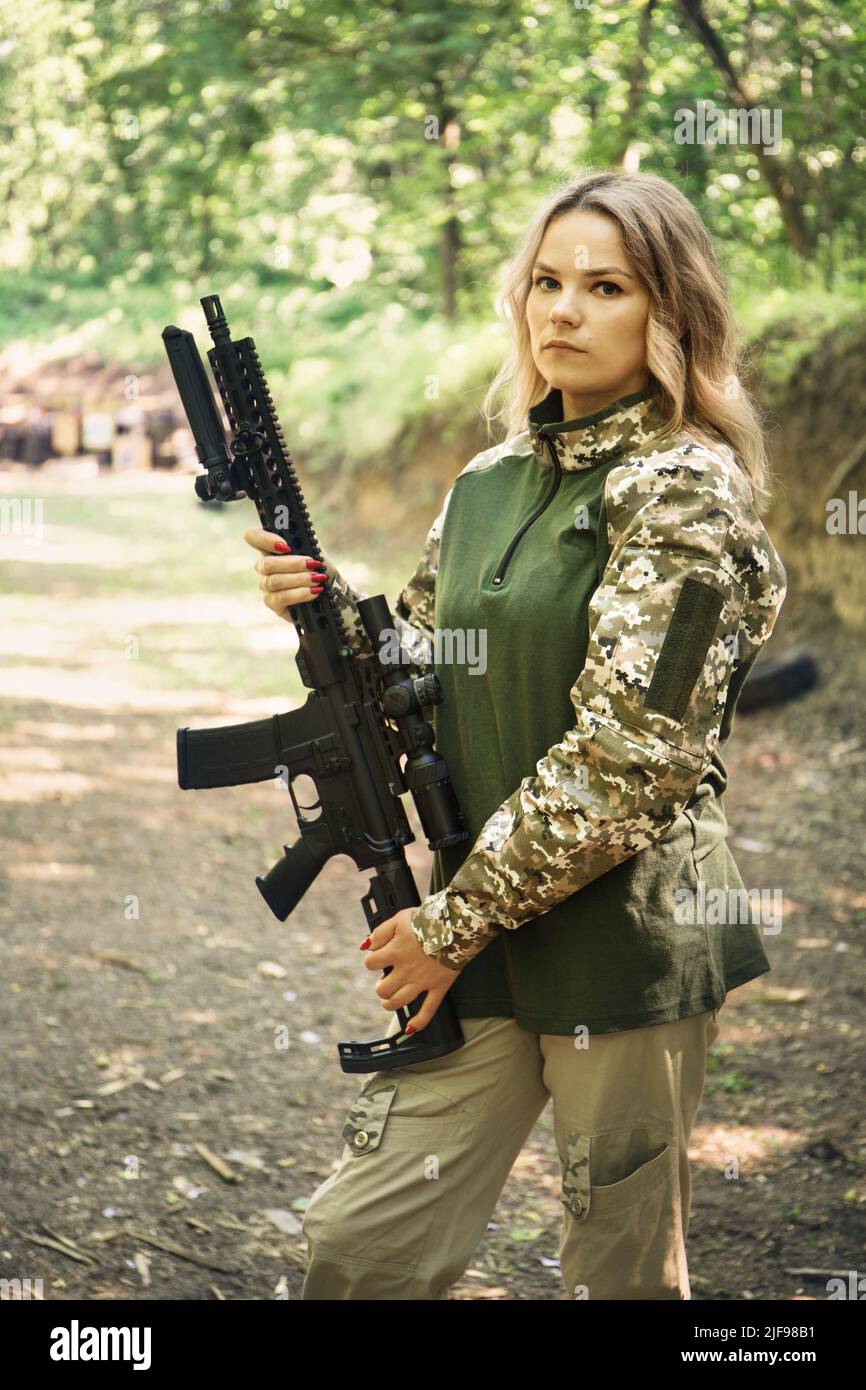 Portrait of a Ukrainian military woman with a assault rifle Ar-15 in ...