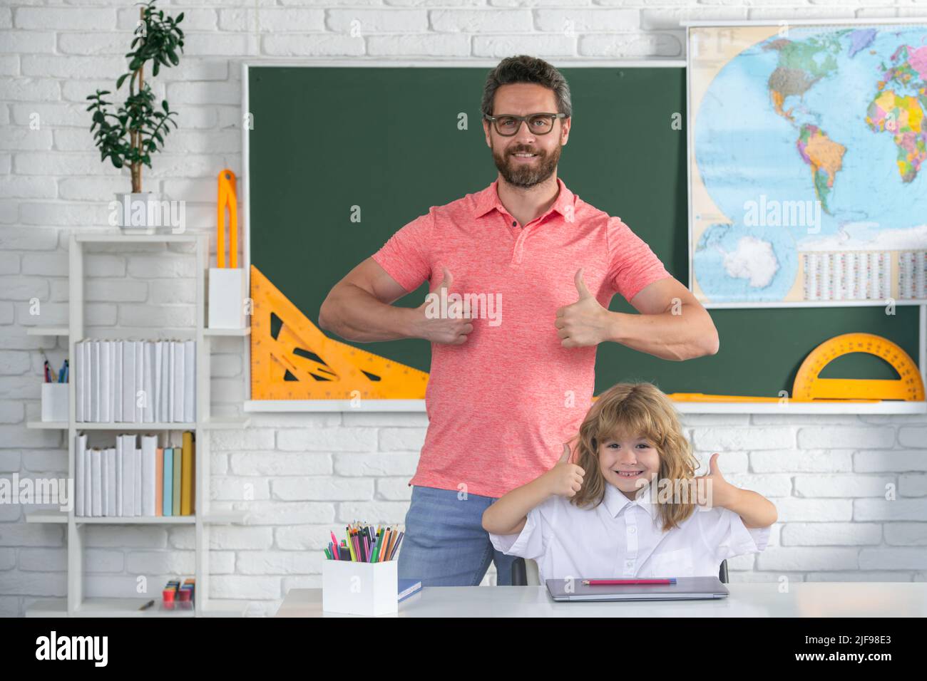 School teacher with a schoolboy. Teacher and students in the classroom. Elementary school boy in ...