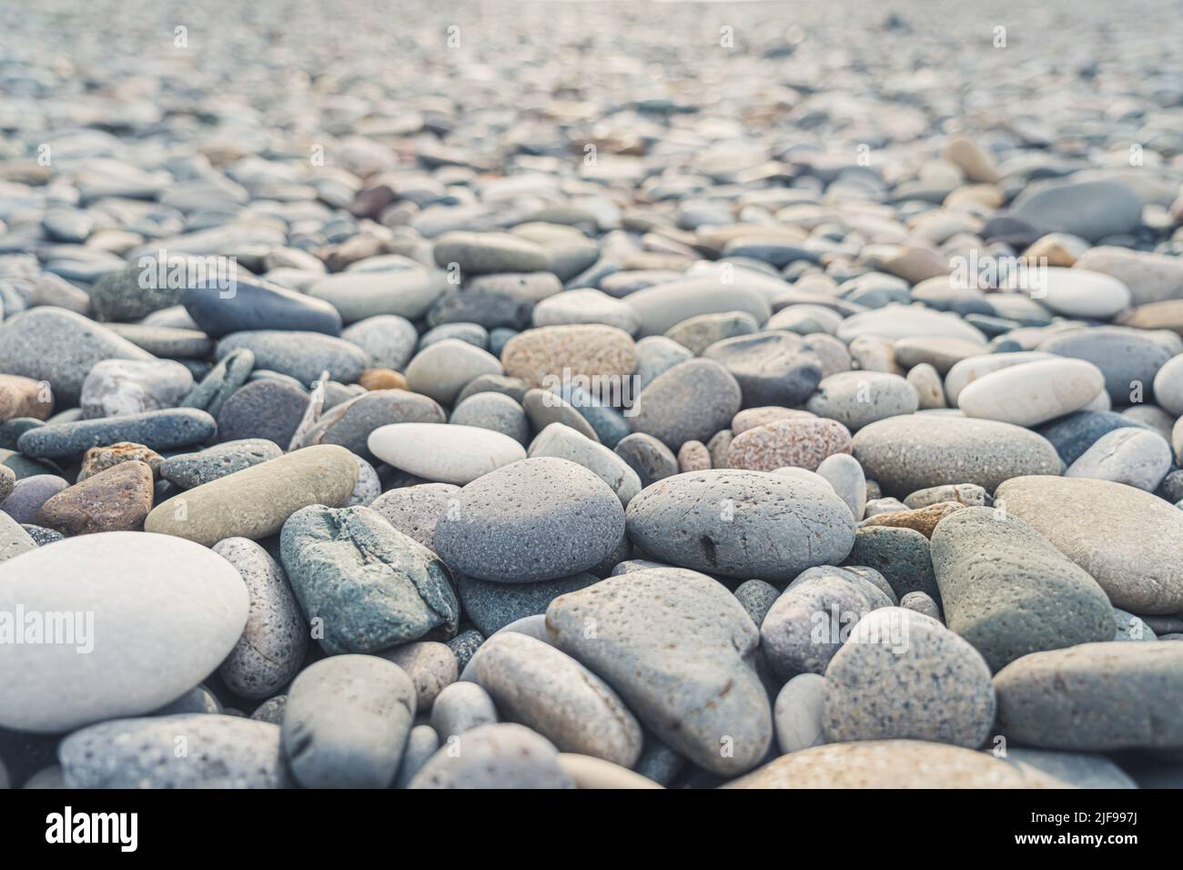 Dry pebbles and stones in soft colors creating an abstract composition ...