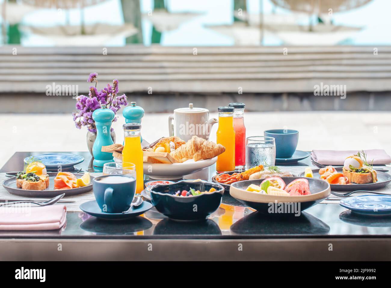 Served breakfast in luxury hotel. Poolside table with various healthy ...