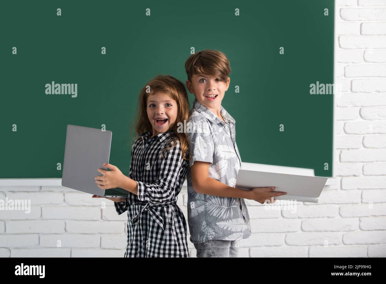 Children boy and girl with laptop computer and book at school Stock ...