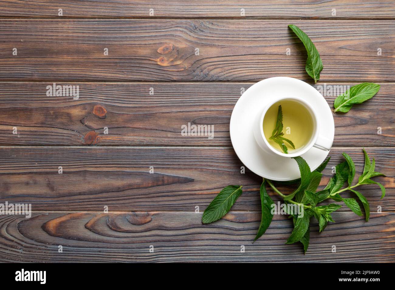 Cup of mint tea on table background. Green tea with fresh mint top view ...