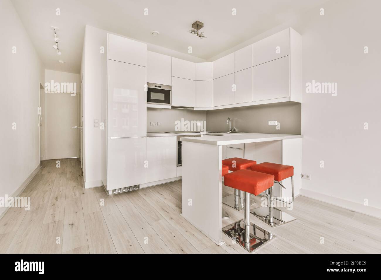 Interior of empty white kitchen with windows and wooden parquet floor ...