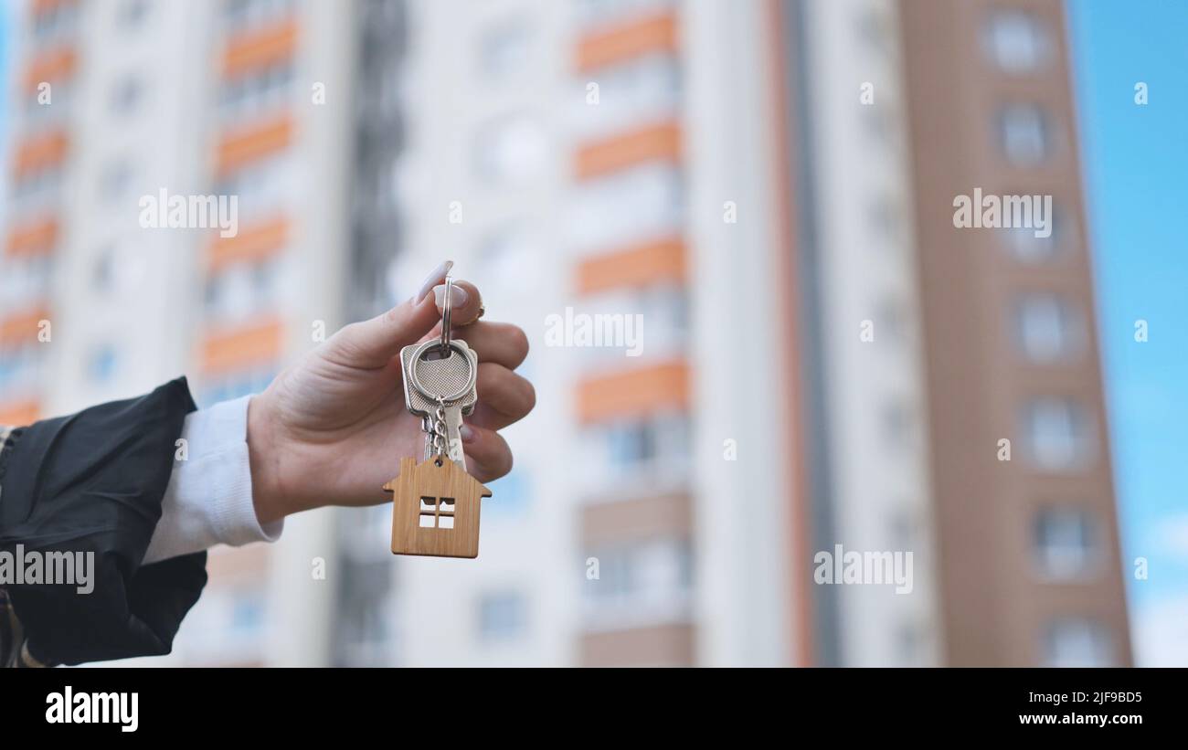 Girl holding keys to apartment against the backdrop of an apartment ...