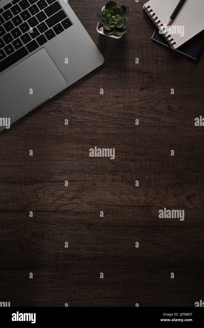 From above view wooden office desk with laptop computer, notepad and ...