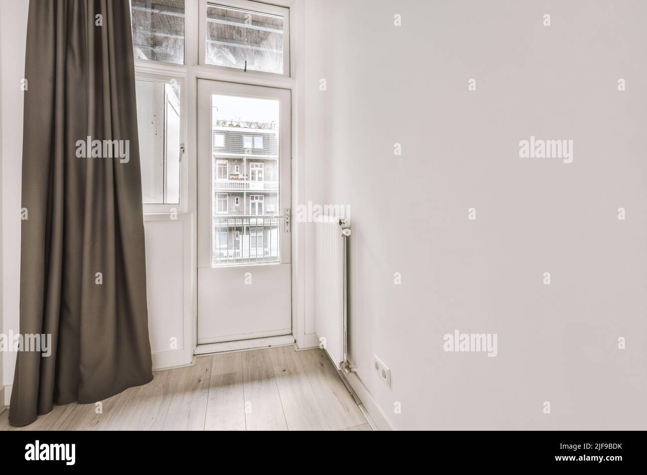 Plastic window and radiator on white wall in empty light room at home ...