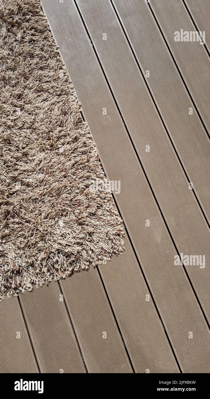 Shaggy carpet on brown wooden floor. Mixed textures in interior. Fluffy ...