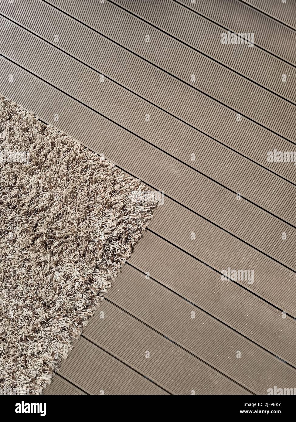 Shaggy carpet on brown wooden floor. Mixed textures in interior. Fluffy ...