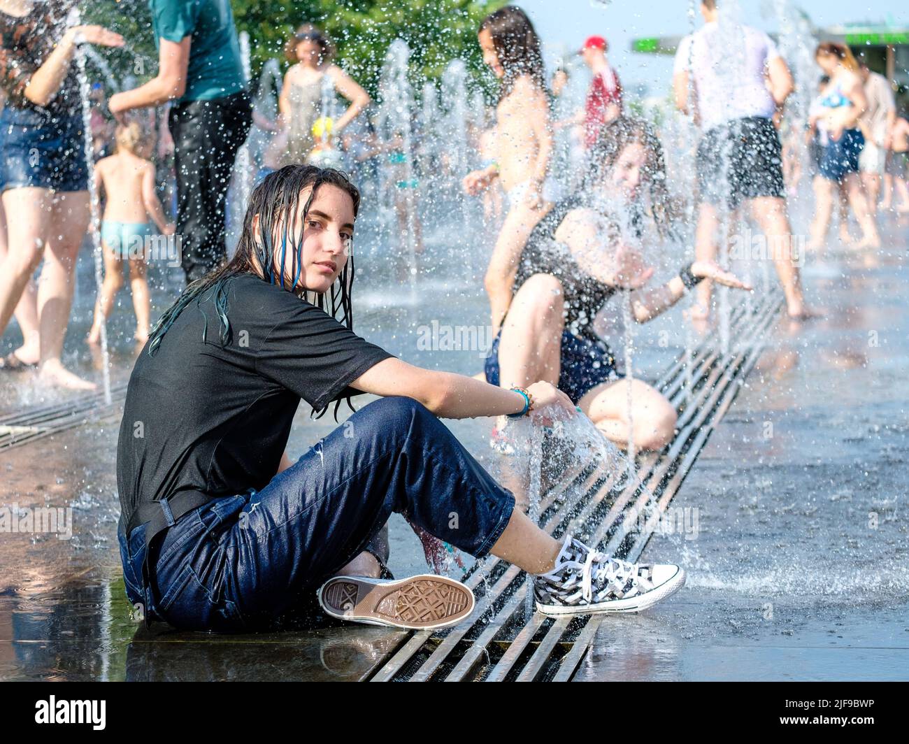 Moscow. Russia. June 26, 2021. A cute young girl in wet clothes bathes ...