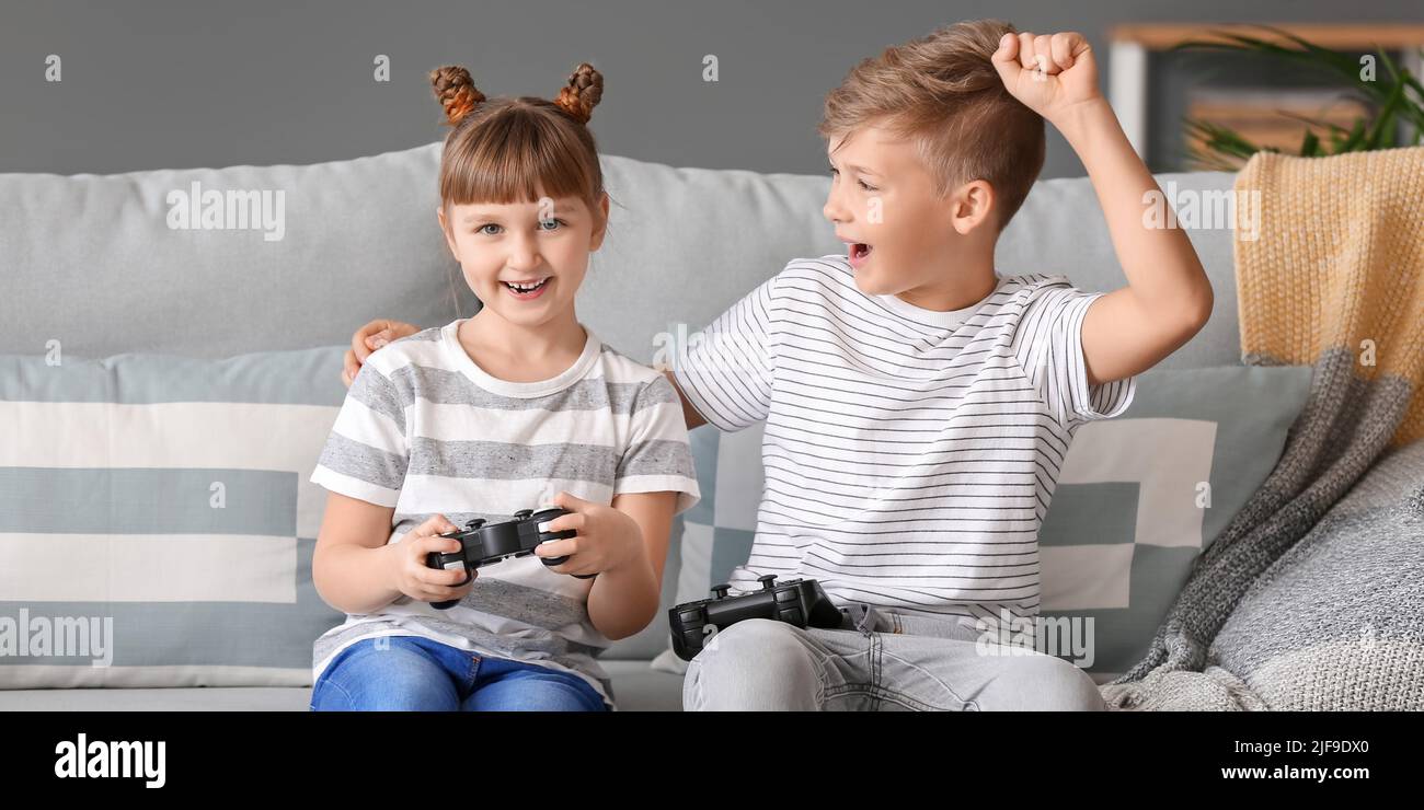 Happy little children playing video games at home Stock Photo - Alamy