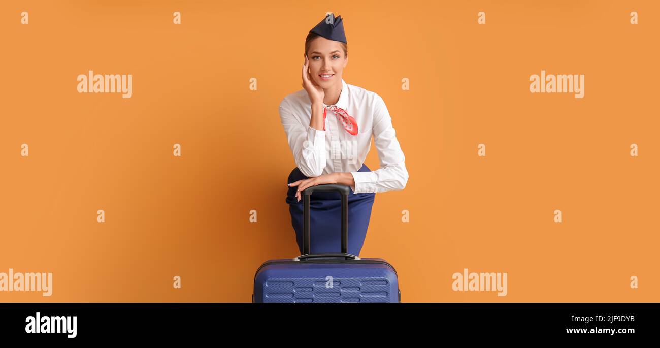 Beautiful stewardess with suitcase on orange background Stock Photo - Alamy