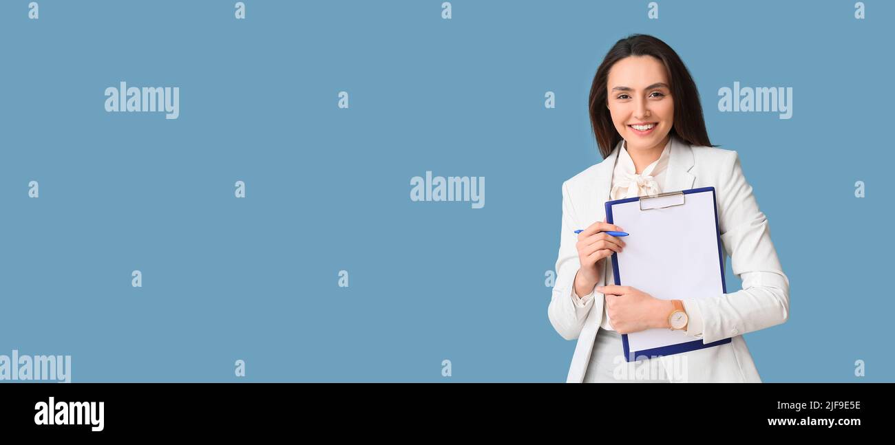 Portrait of young secretary with clipboard on light blue background ...