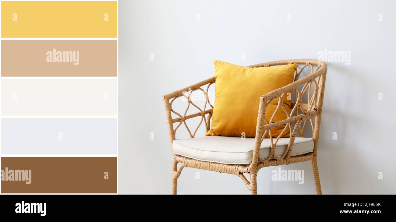 Wicker chair near light wall. Different color patterns Stock Photo - Alamy