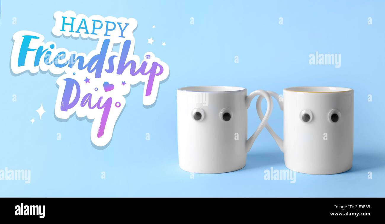 Funny cups and text HAPPY FRIENDSHIP DAY on light blue background Stock ...