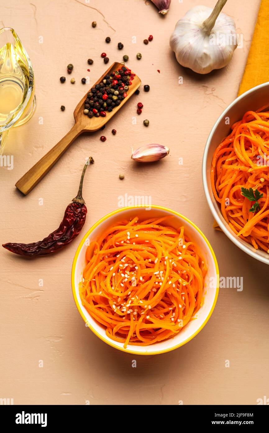Bowl of korean carrot salad and spices on color background Stock Photo ...