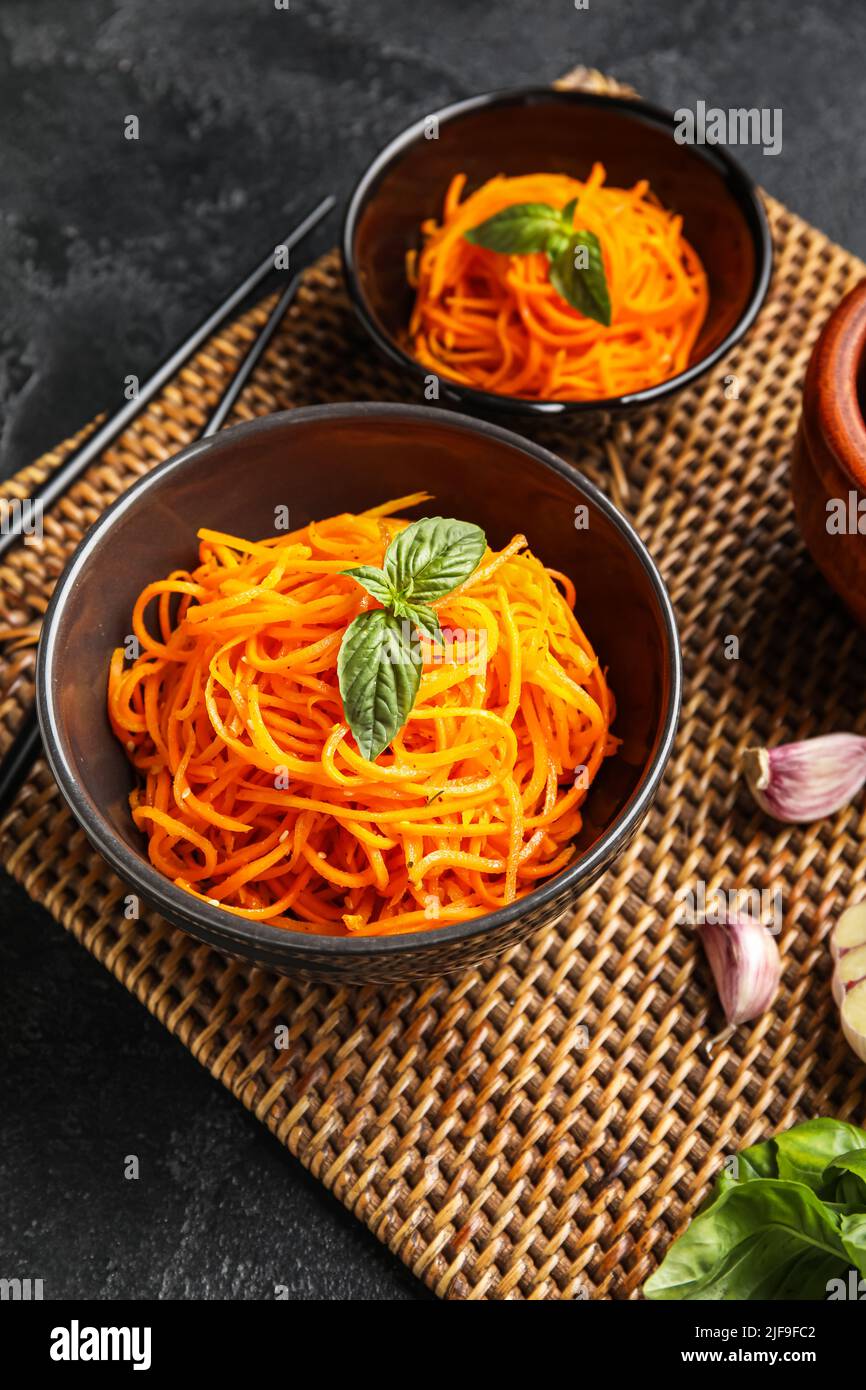 Bowls with spicy carrot salad on wicker mat Stock Photo - Alamy