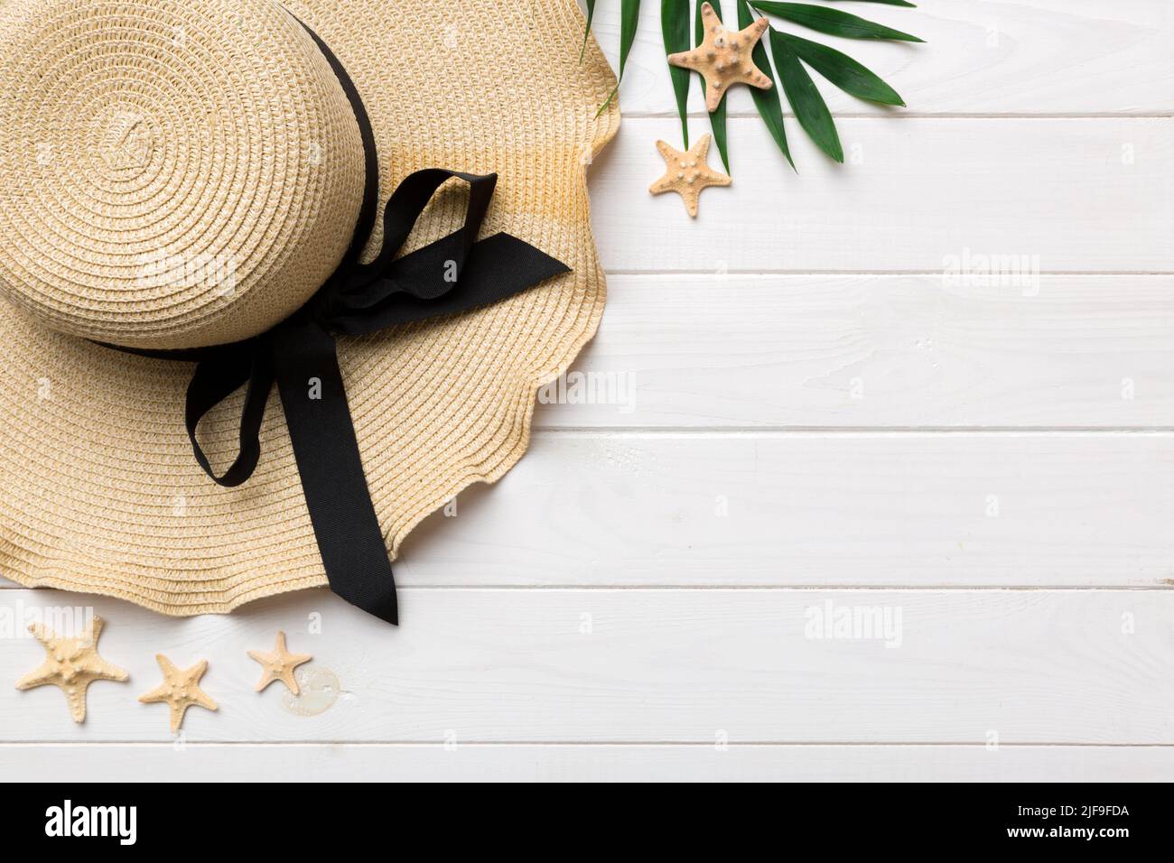 Summer holidays. Summer concept with straw hat and tropical leaf. Flat ...