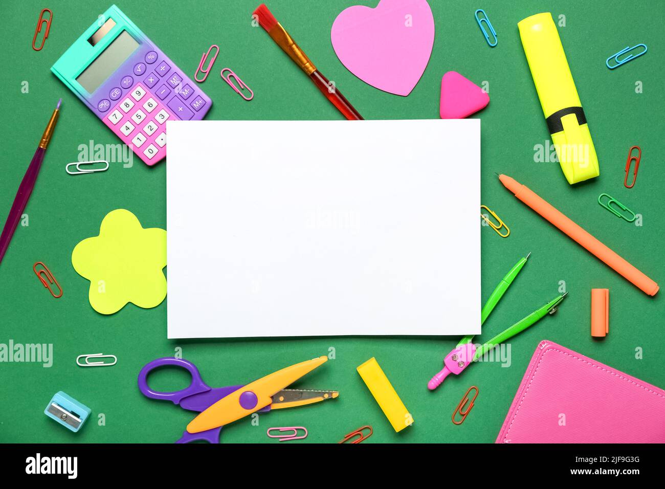 Blank paper sheet with school stationery on green background Stock ...