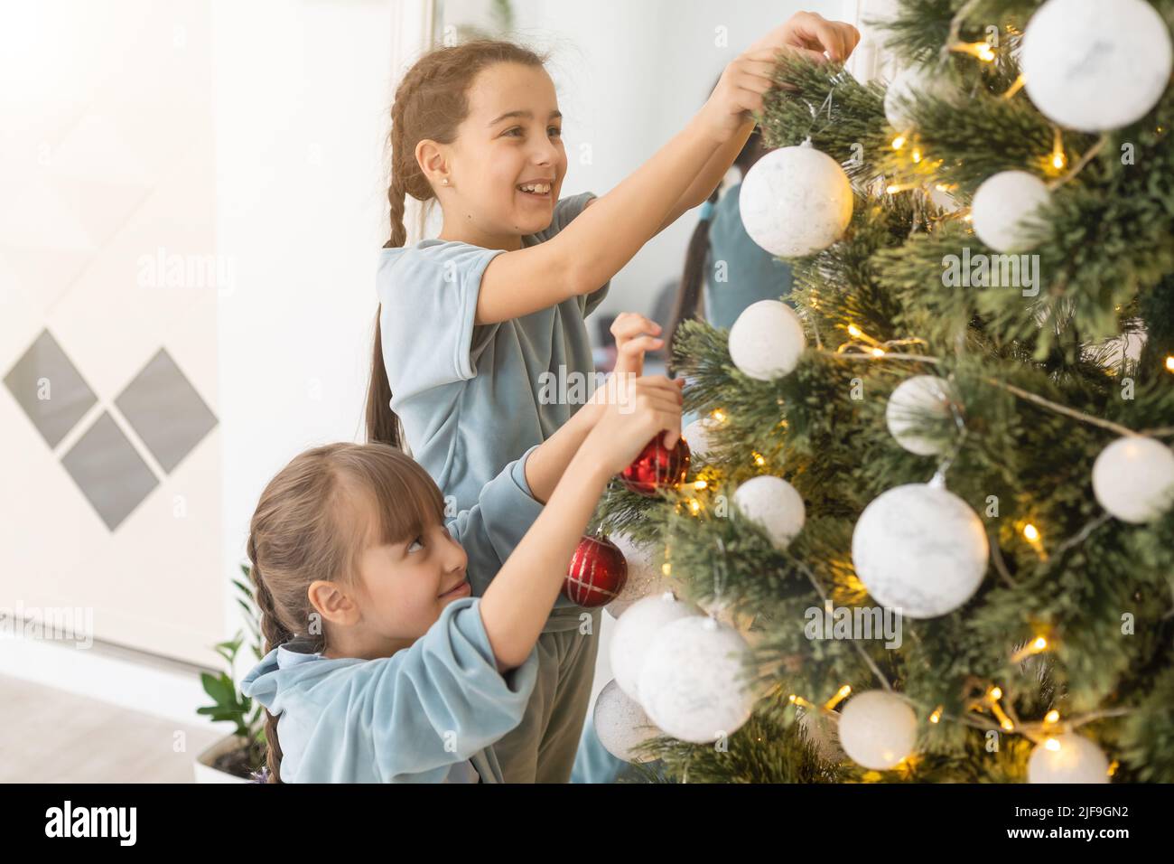 Two cute little girls under Christmas tree. Children under Christmas ...