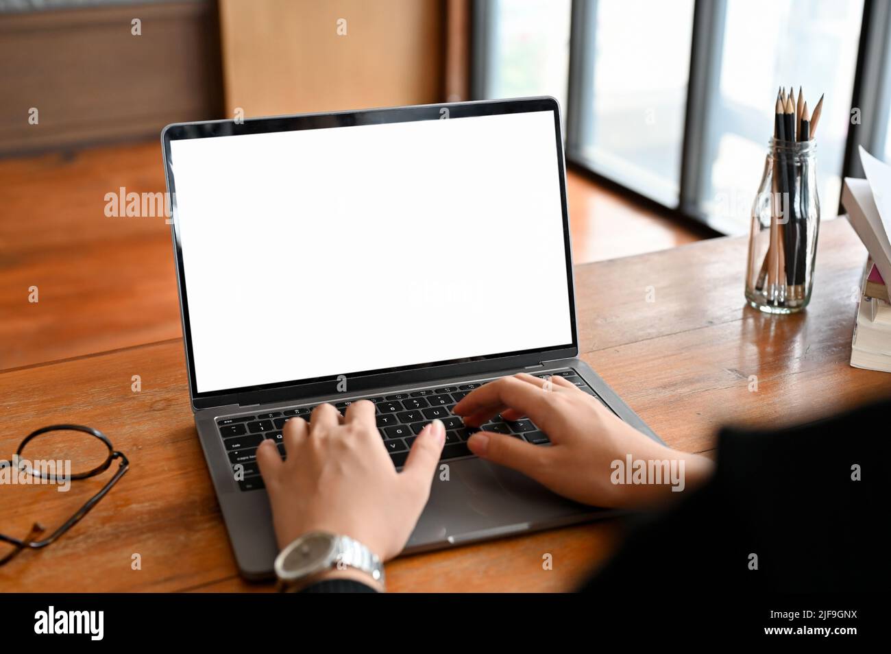 A businessman working at his desk, using laptop computer to manage his ...
