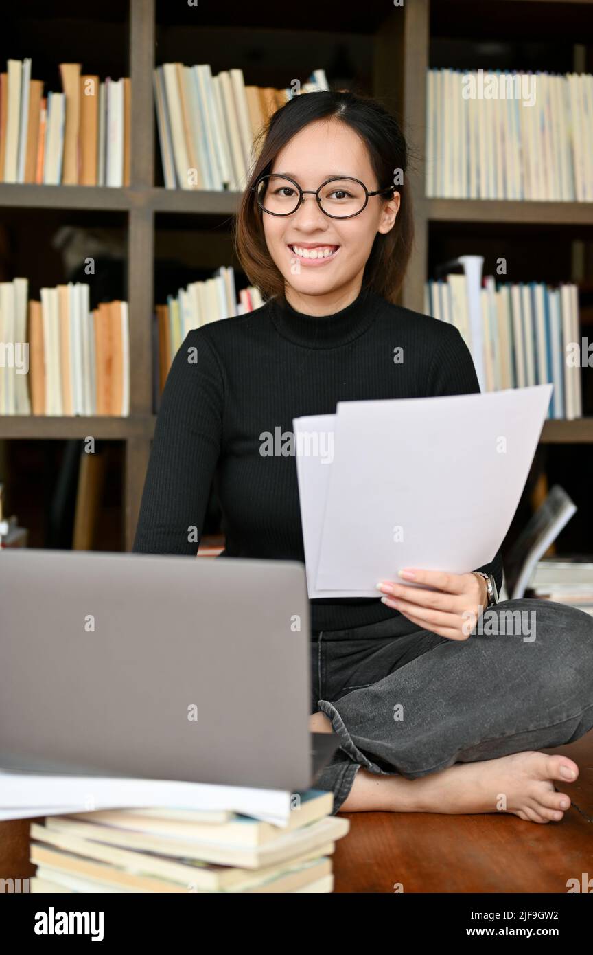 Nerd young asian female college student doing her research in the ...